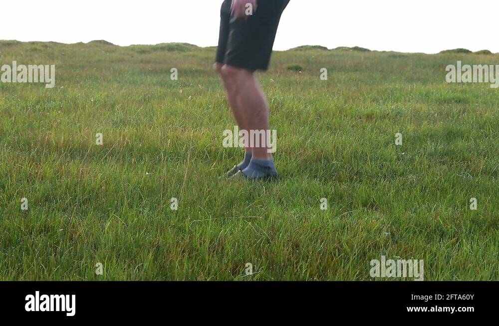 Point of view of man walking barefoot through grass field Stock Video ...