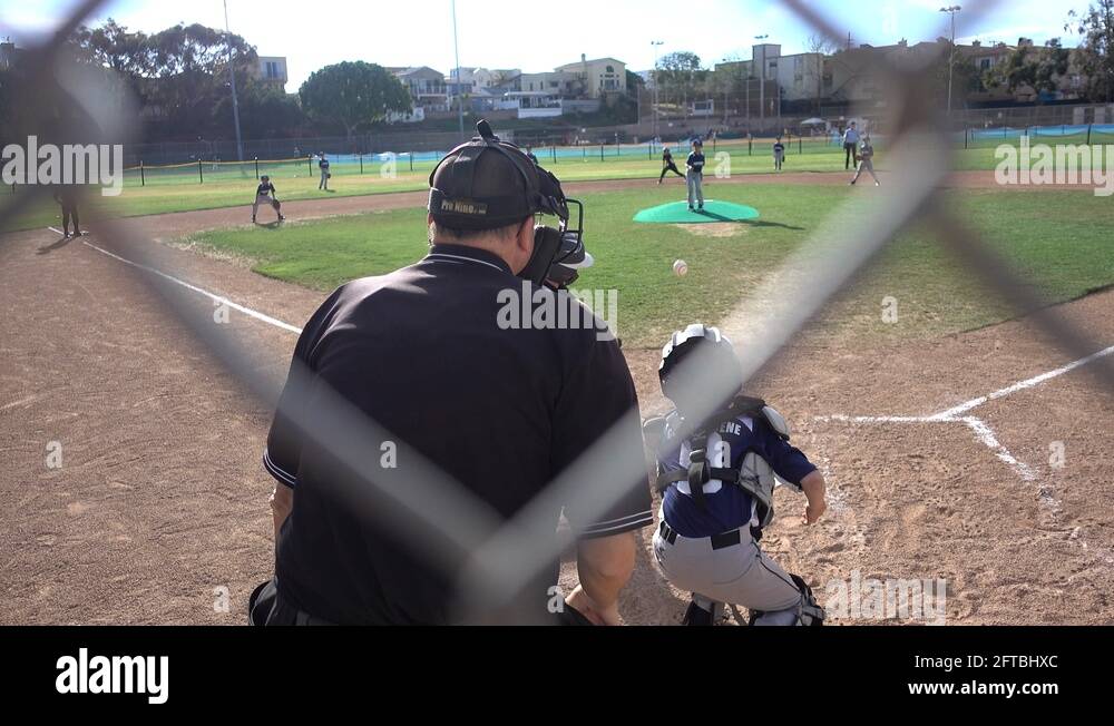Boys playing in a little league baseball game through a chain-link ...