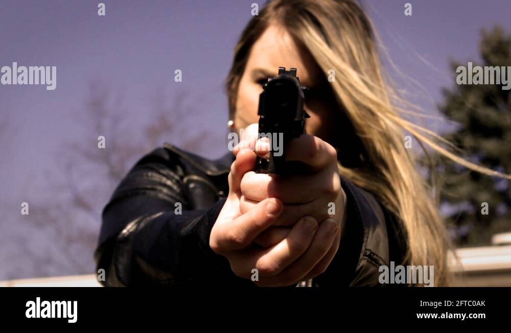 Female Secret Agent aims pistol at camera V1 Action Movie Shots Stock ...