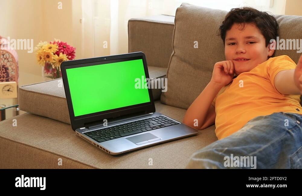 Young boy with green screen laptop monitor Stock Video Footage - Alamy