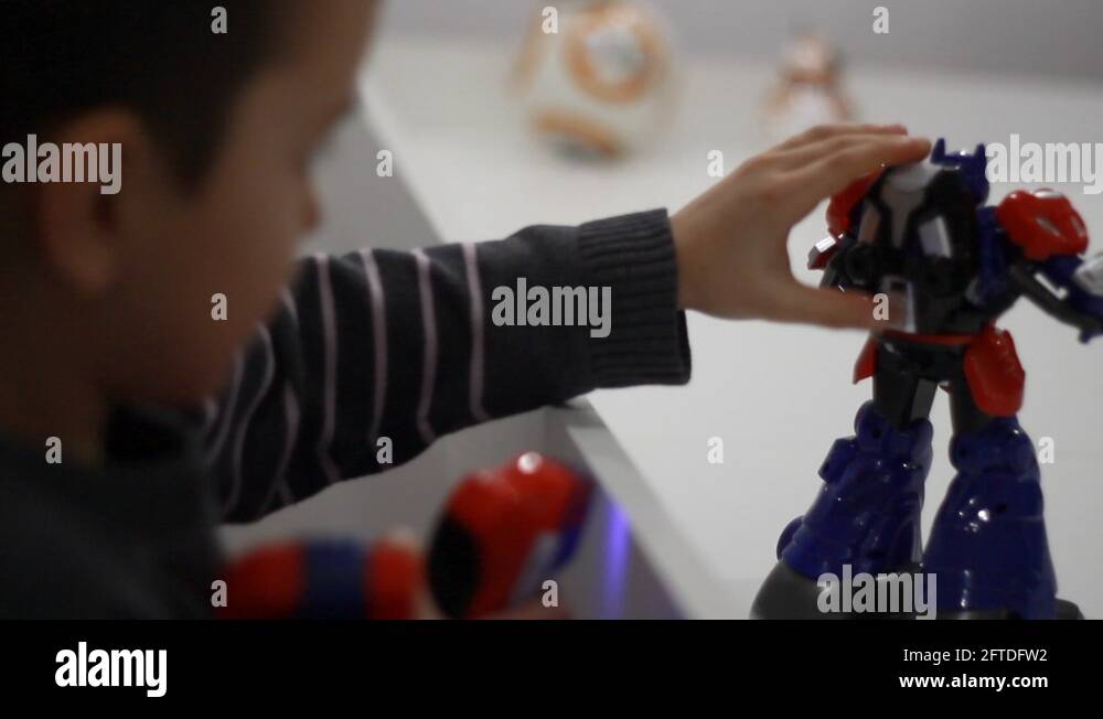 Boy turn on robot toy. Robot and child playing. Boy check toy robot ...
