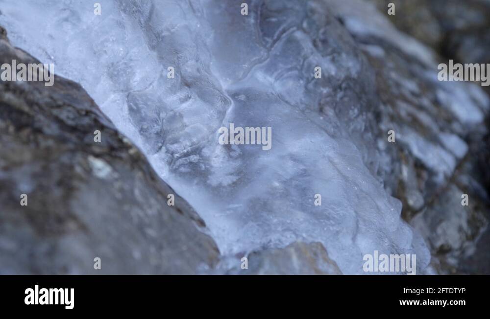Ice melting - ECU detail of meltwater droplets flowing under glacial ...