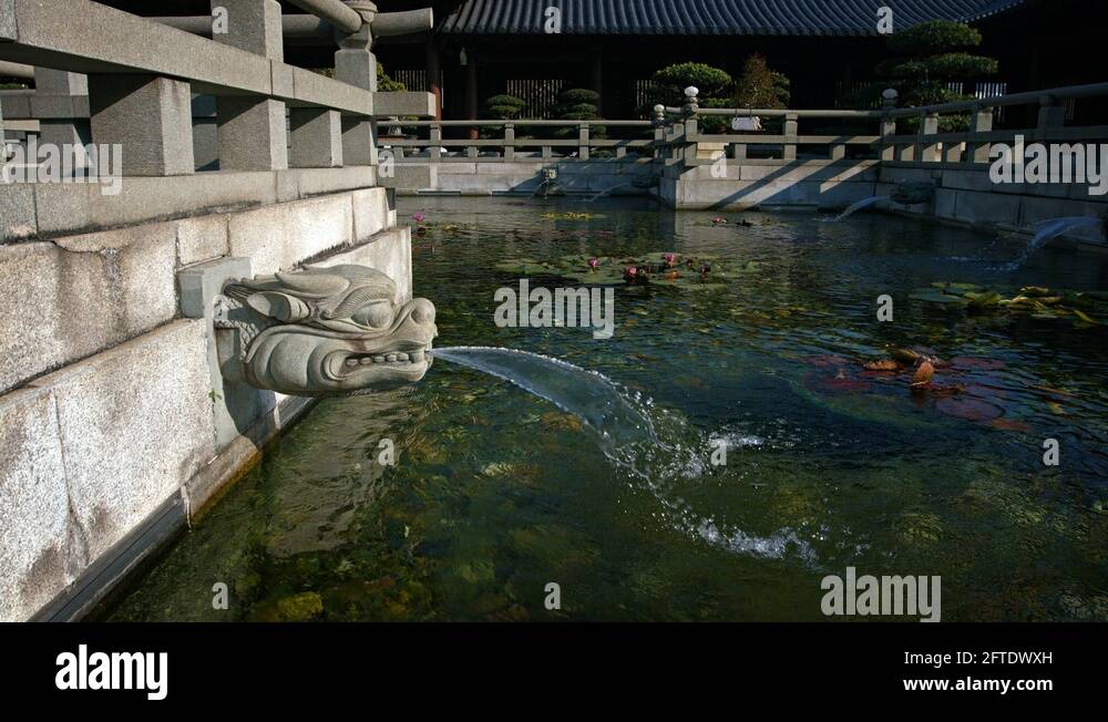 Sculpted fountain depicting a dragon's head emits a stream of water ...
