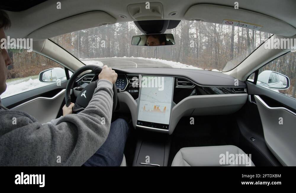 CLOSE UP: Man driving Tesla Model S all-electric car on winding country ...