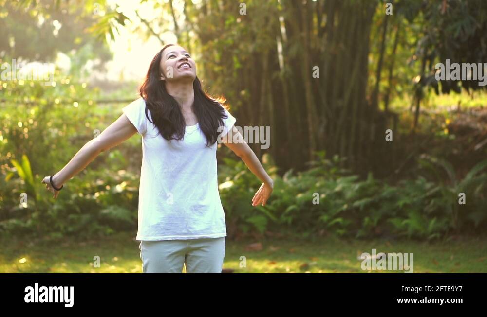 Asian mixed race girl happily turn around and smile in morning nature ...