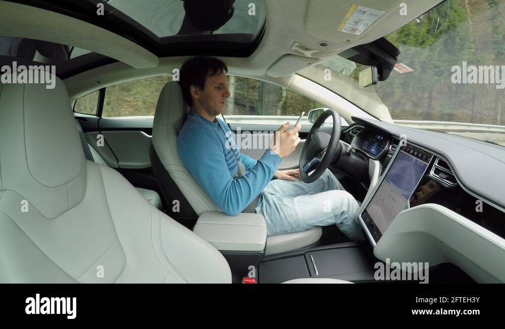 Driver typing messages while driving in luxury autonomous autopilot ...
