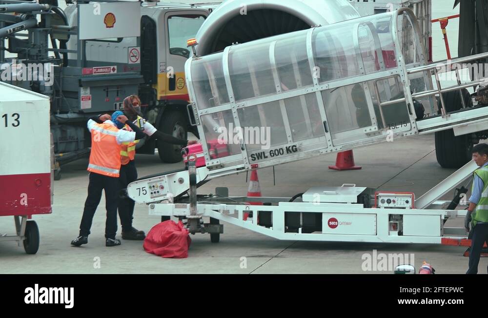 Ground Crew Unloading Bags at Changi International Airport in Singapore ...