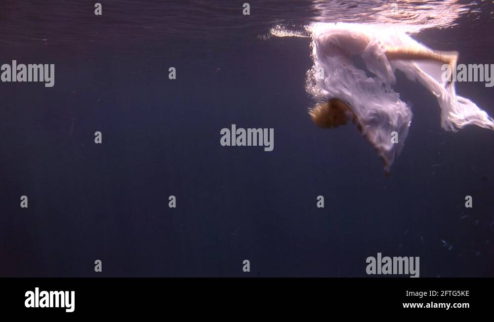 Young girl model free diver underwater white angel costume poses in Red ...
