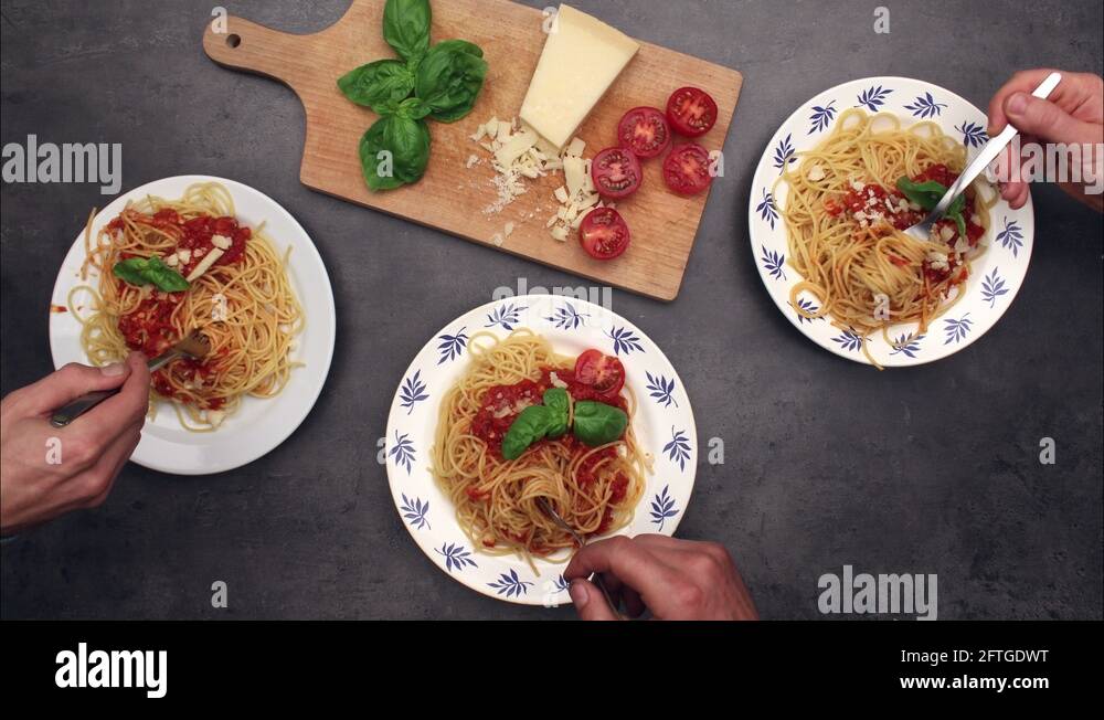 Serving and eating spaghetti with friends. Top view, stop motion, 4K ...