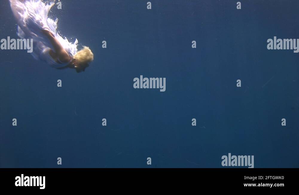 Young girl model free diver underwater white angel costume poses in Red ...