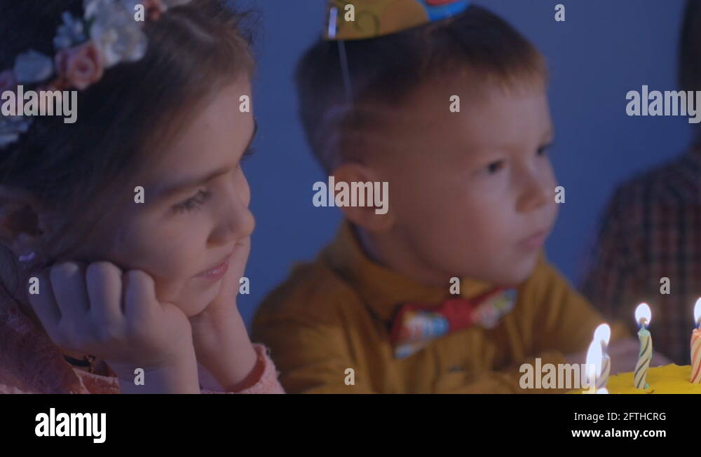 little kids sit at red table with cake. Happy group of children at ...