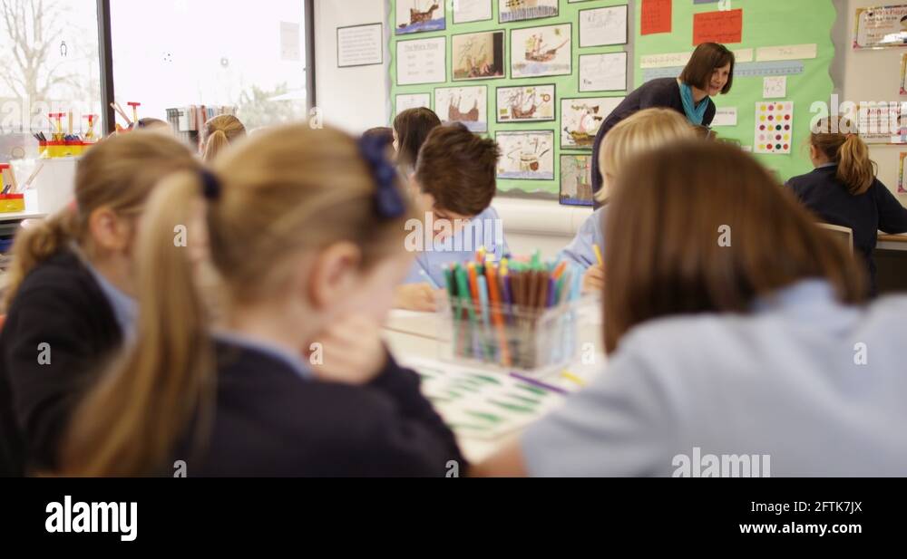 4K Young children working in groups in school classroom with teacher ...
