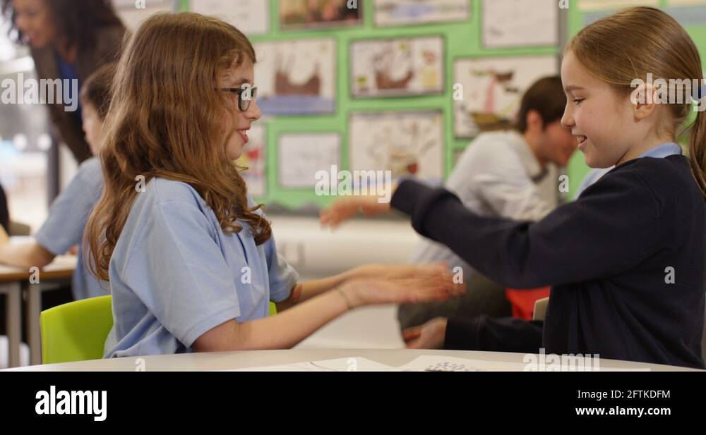 4K Cute little girls playing pat-a-cake together in school classroom ...