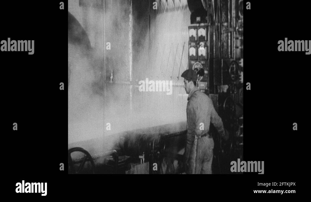 1930s-1940s : A factory worker operates a machine that runs sheets of ...