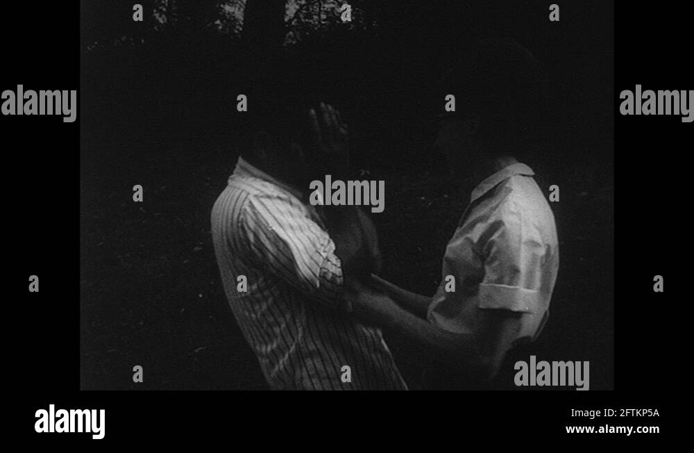 1960s: woman scratches man / man puts hands on face / woman biting mans ...