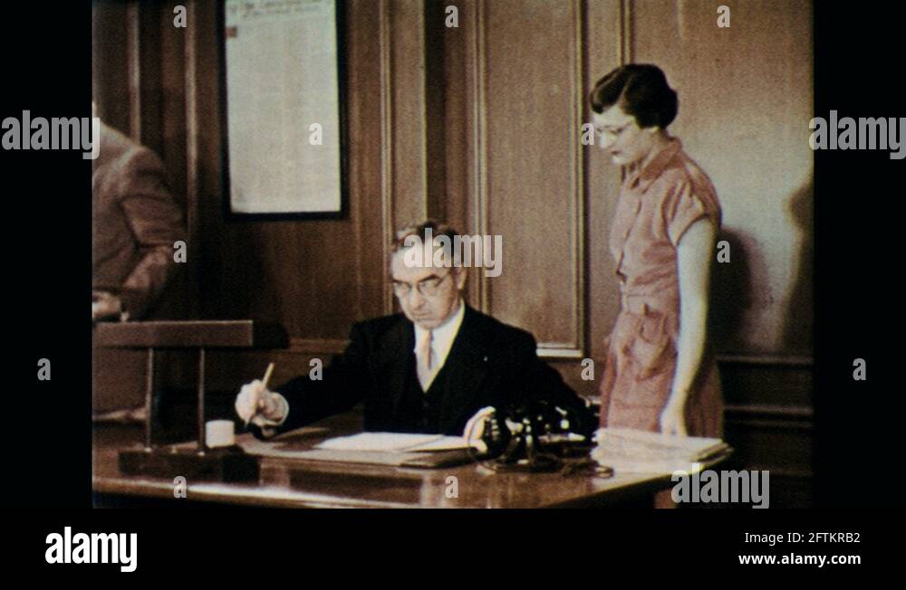 1950s: In a government office, a public figure signs papers as his ...
