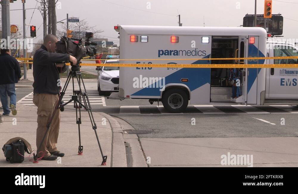 Broadcast TV television news camera and ambulance at emergency scene ...