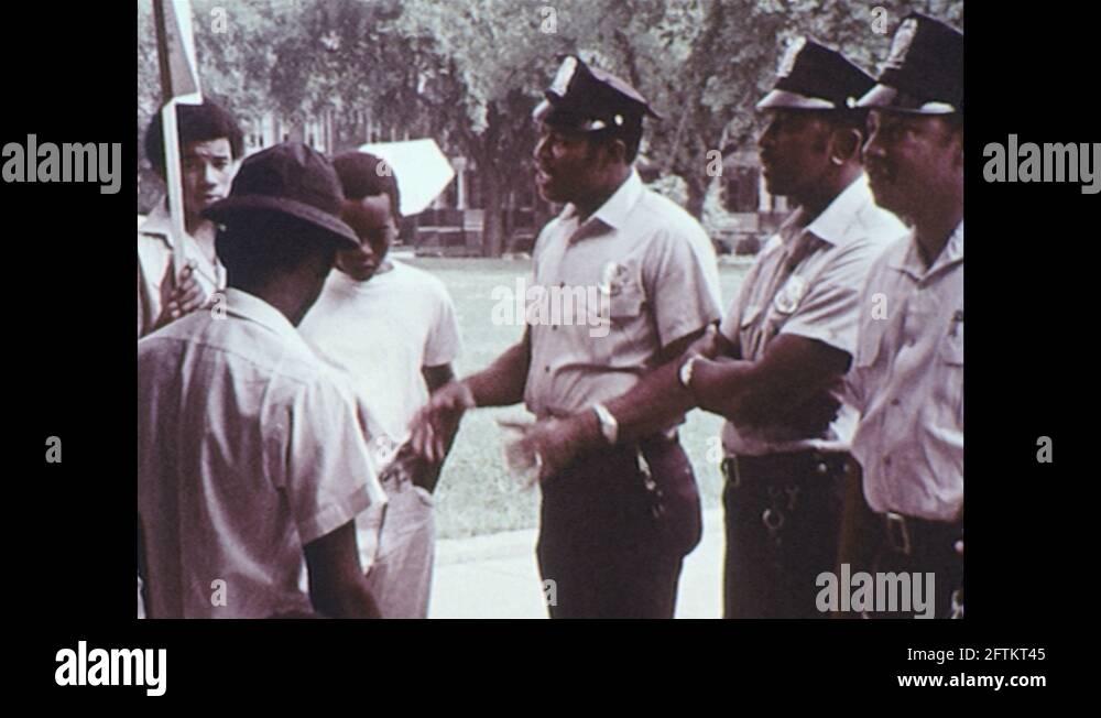 1970s: Police officers talk to group of boys / zoom in on officer ...