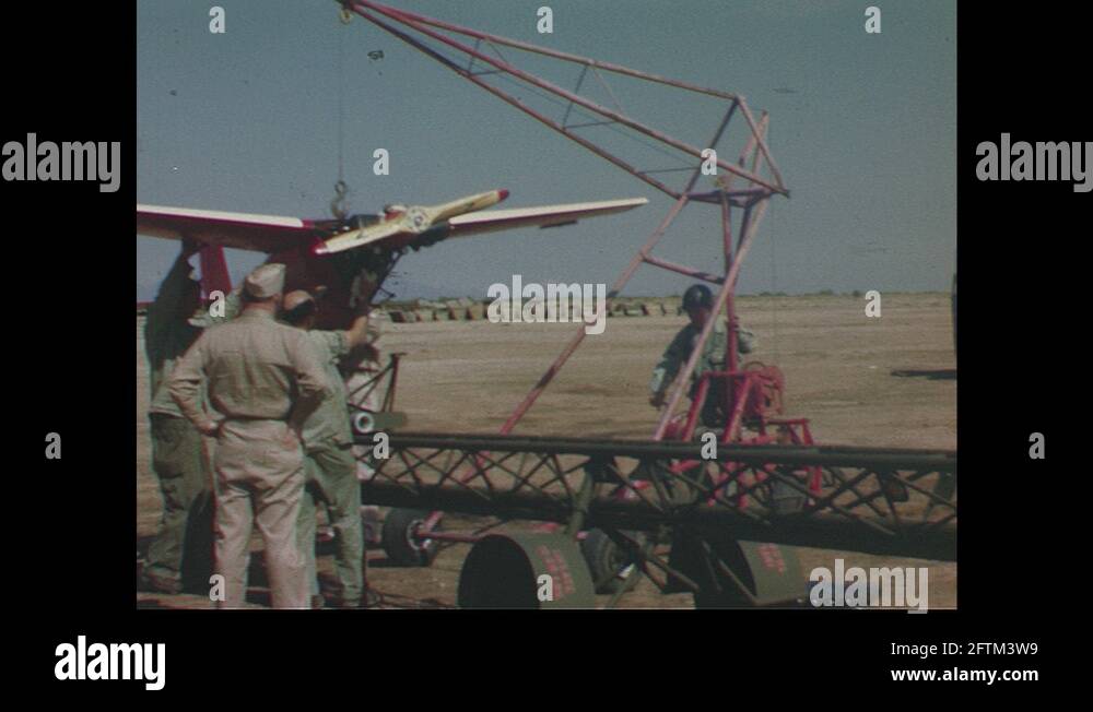 1950s : Men in military uniforms hoist the plane down onto the catapult ...