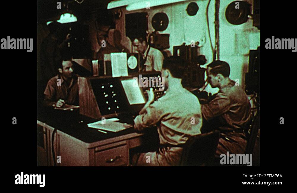 1950s: Men at control panels / Man consults card, speaks into ...