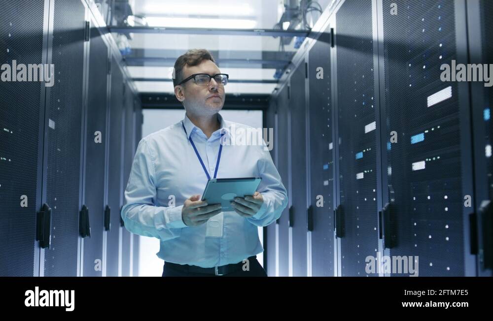 IT Technician Walks Through Rows of Server Racks in Data Center Stock ...