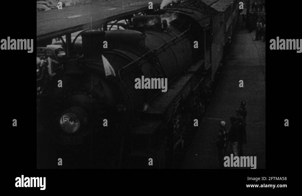 1940s: A train arrives at a railroad station early in the day Stock ...