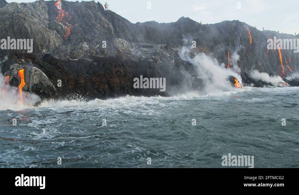 Erupting volcanic red hot lava pouring into the Pacific ocean from ...