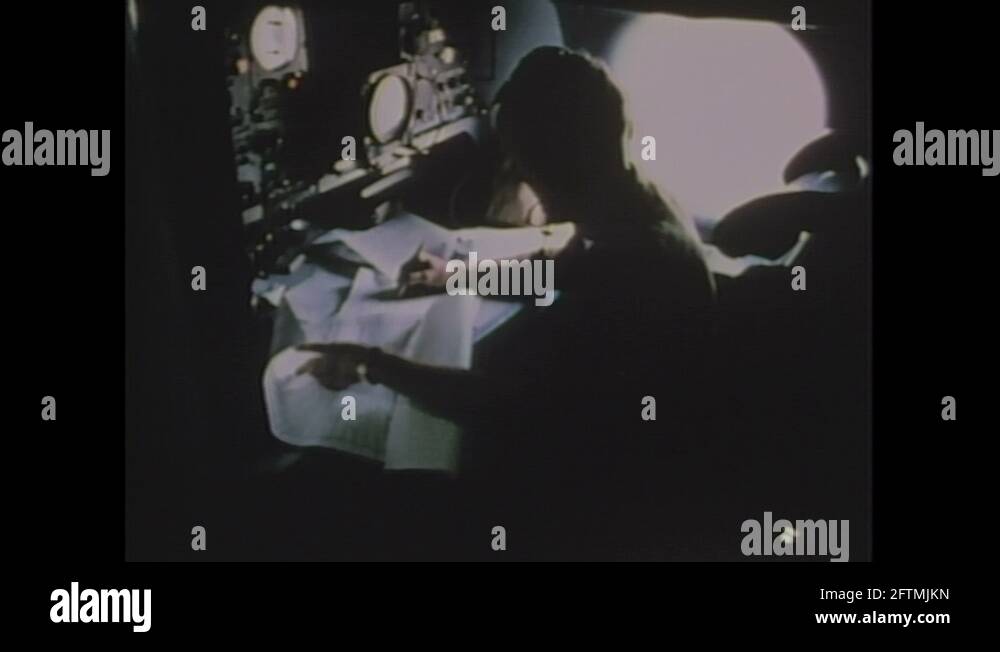 1970s: Man in lab takes notes / Man with radio equipment / Hands push ...
