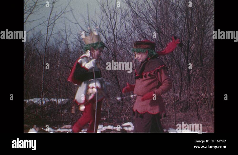 Two characters dressed as jesters exchange positions atop a snow ...