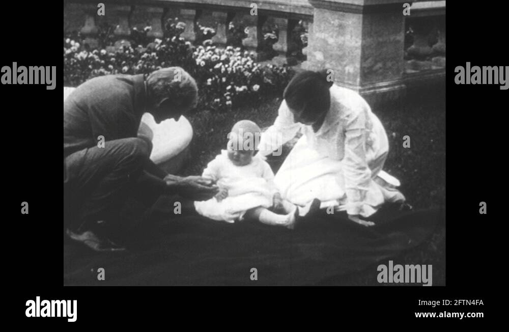 1950s: Henry Ford shows grandchild baby bird. In garden with family ...