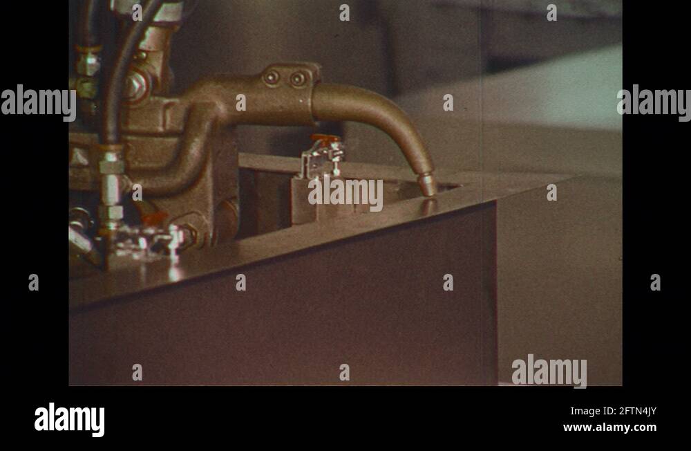 1980s: industrial robotic arm works at assembly line. It tracks metal ...