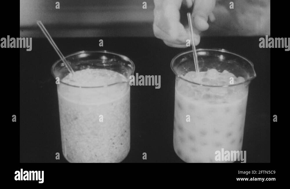 1960s: two beakers filled / hand uses glass rod to mix solution inside ...