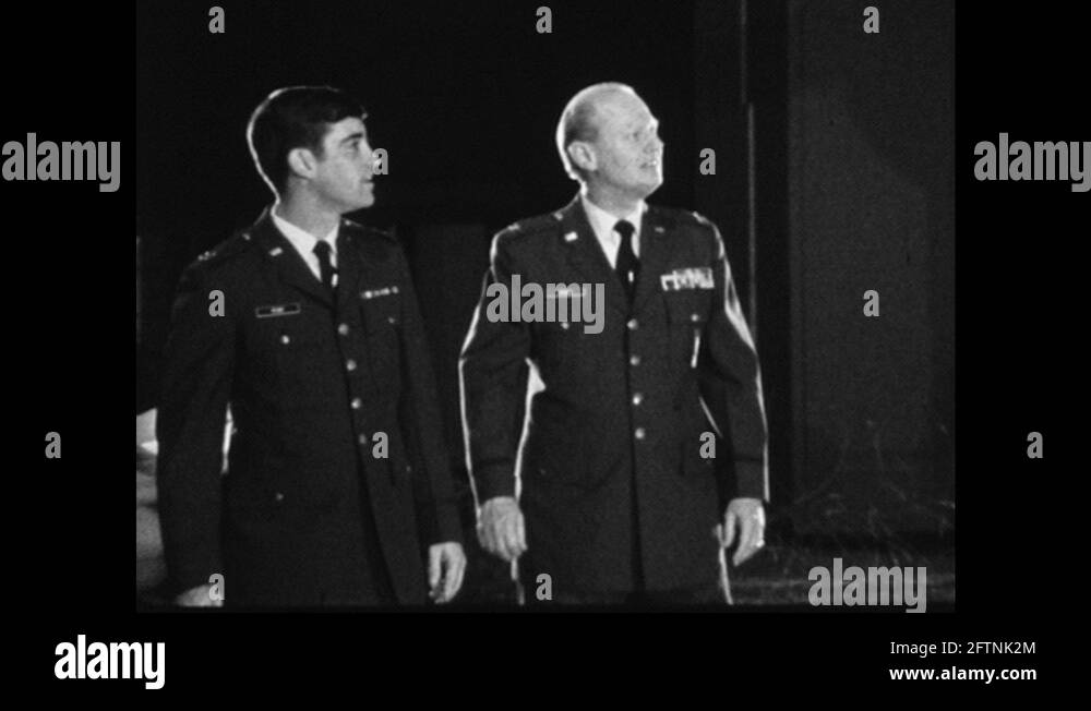 1960s: Airforce pilots visit vintage planes in museum. Men talk in ...