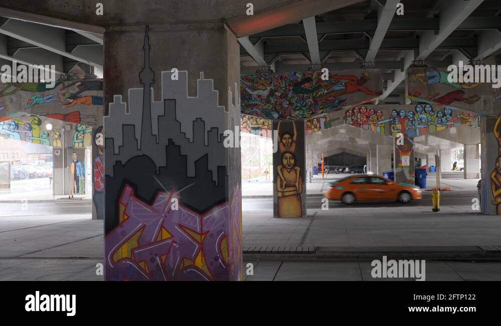 Street art on pillar at Toronto Underpass skatepark. Taxi goes by Stock ...