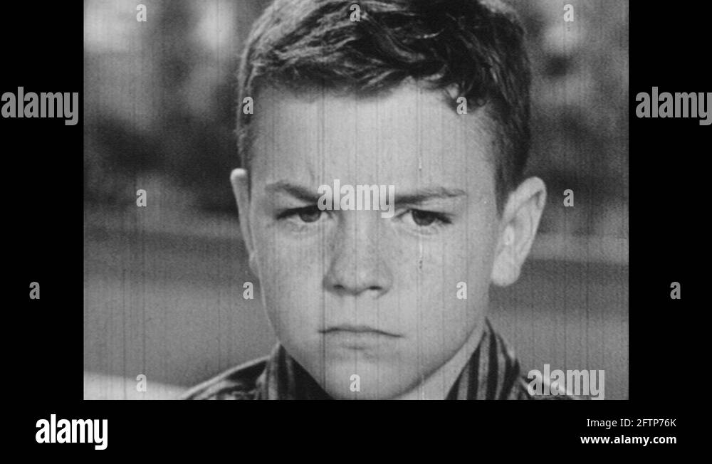 UNITED STATES: 1950s: Teacher enters classroom and looks at blackboard ...