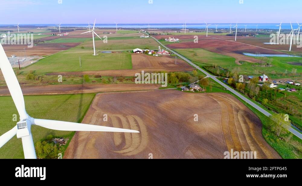 Giant wind turbines dominate the landscape, dwarfing farms and silos ...