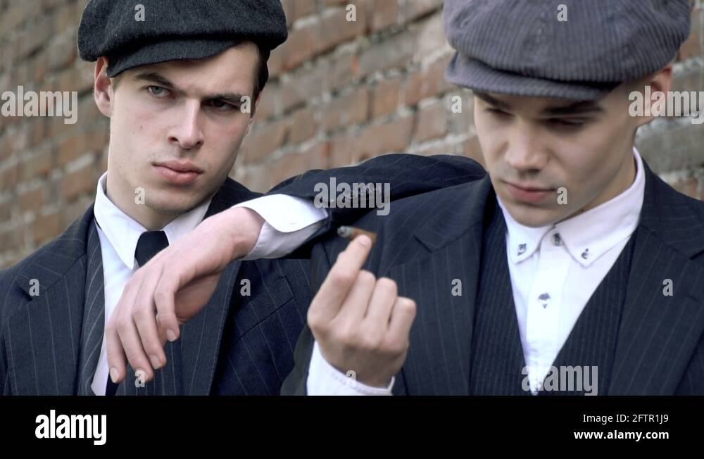 Two guys in suits of gangsters of the 1920s pose against the wall Stock ...