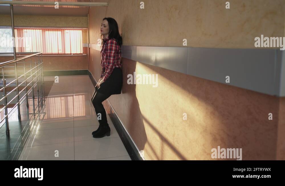 woman in office standing next to wall, sitting down in hall Stock Video ...