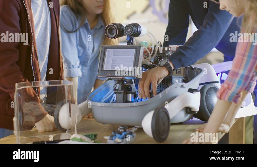 Teacher and His Pupils Work on a Programable Robot with LED lights ...