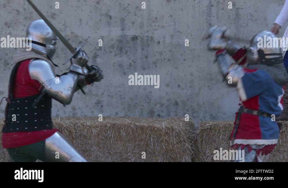Two men dressing medieval metal armor fight a sword-fired duel. Slow ...