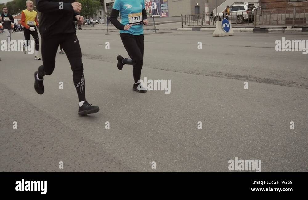 Unidentified marathon athletes legs running on city road, sport legs ...