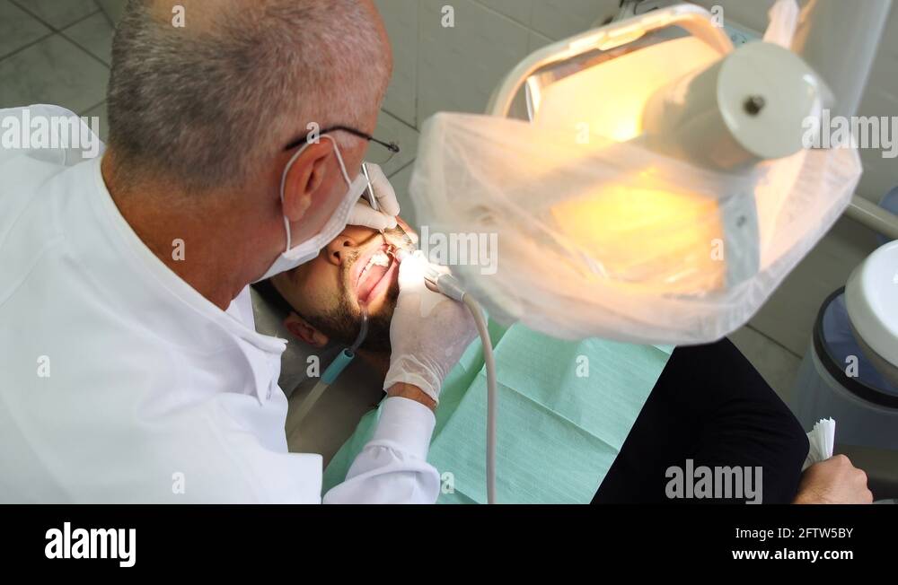 Dentist curing a male patient Stock Video Footage - Alamy