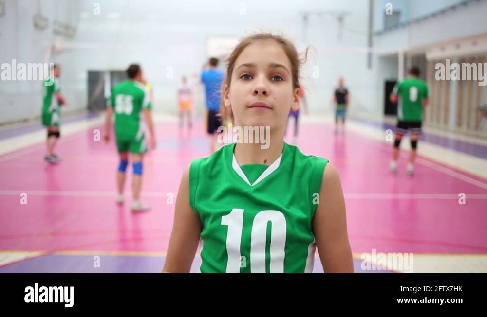little girl is throwing the ball and clapping hands behind volleyball ...