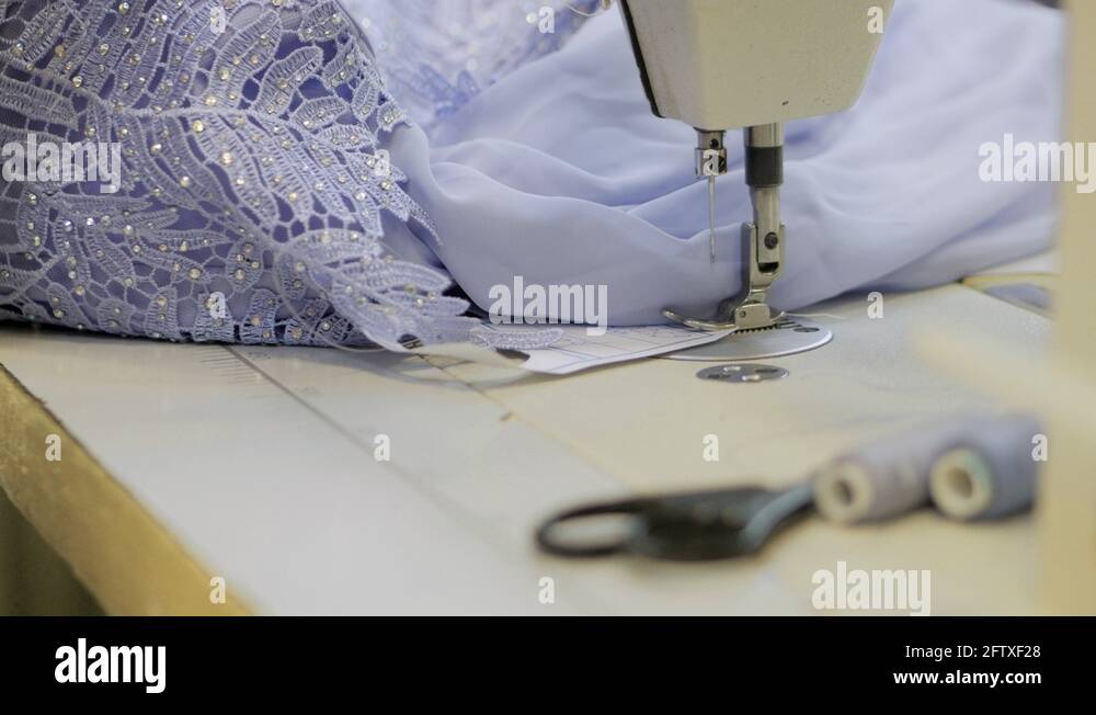 Close up footage of a professional woman tailor is ripping off a cotton ...