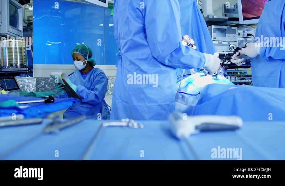 Caucasian hospital surgeons performing surgical Laparoscopy operation ...