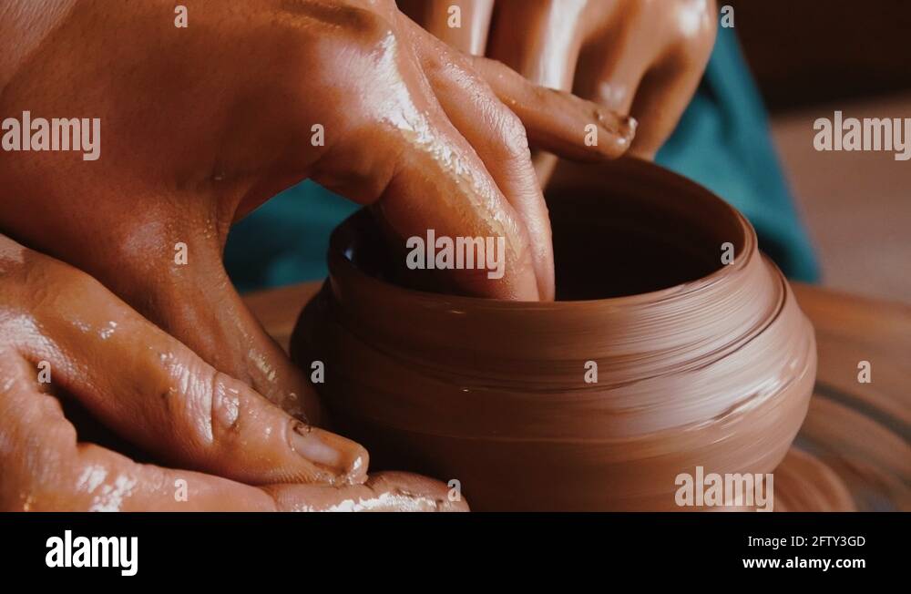 Creating a clay pot.Potter.Hands working on pottery wheel, shaping a ...
