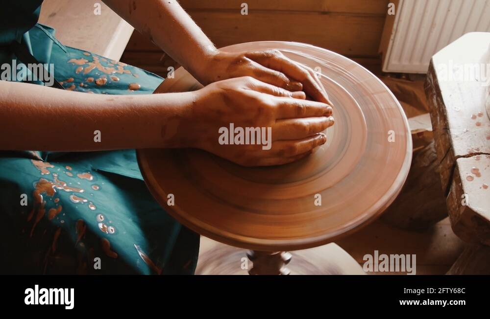 Creating a clay pot.Potter.Hands working on pottery wheel, shaping a ...