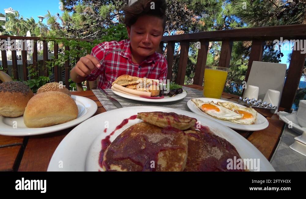 Preteen boy eating breakfast and crying Stock Video Footage - Alamy