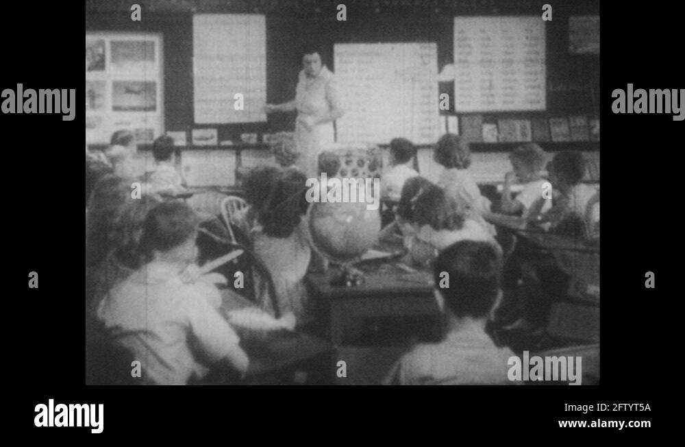 1940s: Teacher stands in front of blackboard, speaks to children in ...