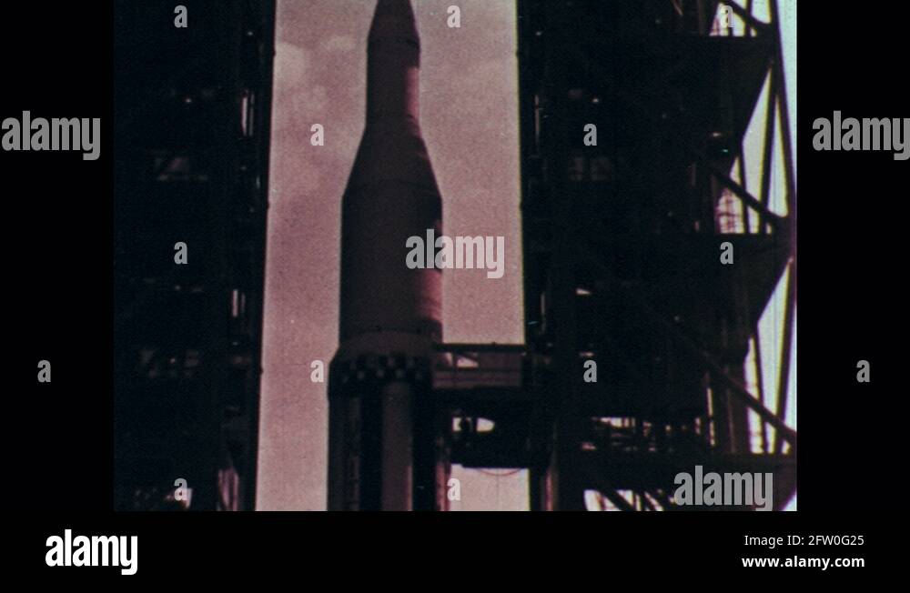1960s: Stationary rocket in upright position. People busy at bottom of ...